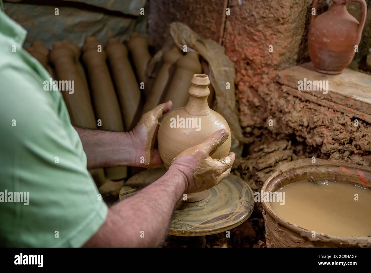 Male potter makes a pot on the pottery wheel. Terracotta pottery guy on ...