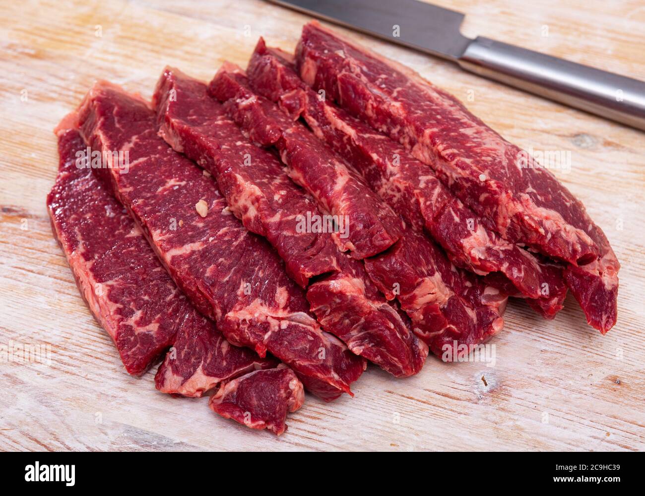 Raw juicy marbled beef entrecotes on wooden surface. Traditional deli ...