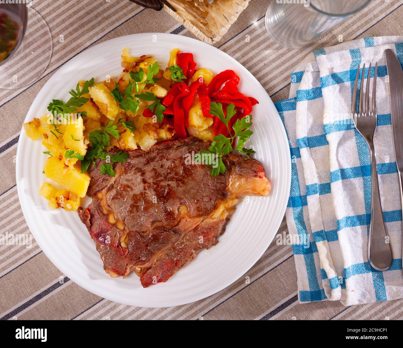 Fried veal cutlet with roasted vegetable garnish of potato and pepper ...