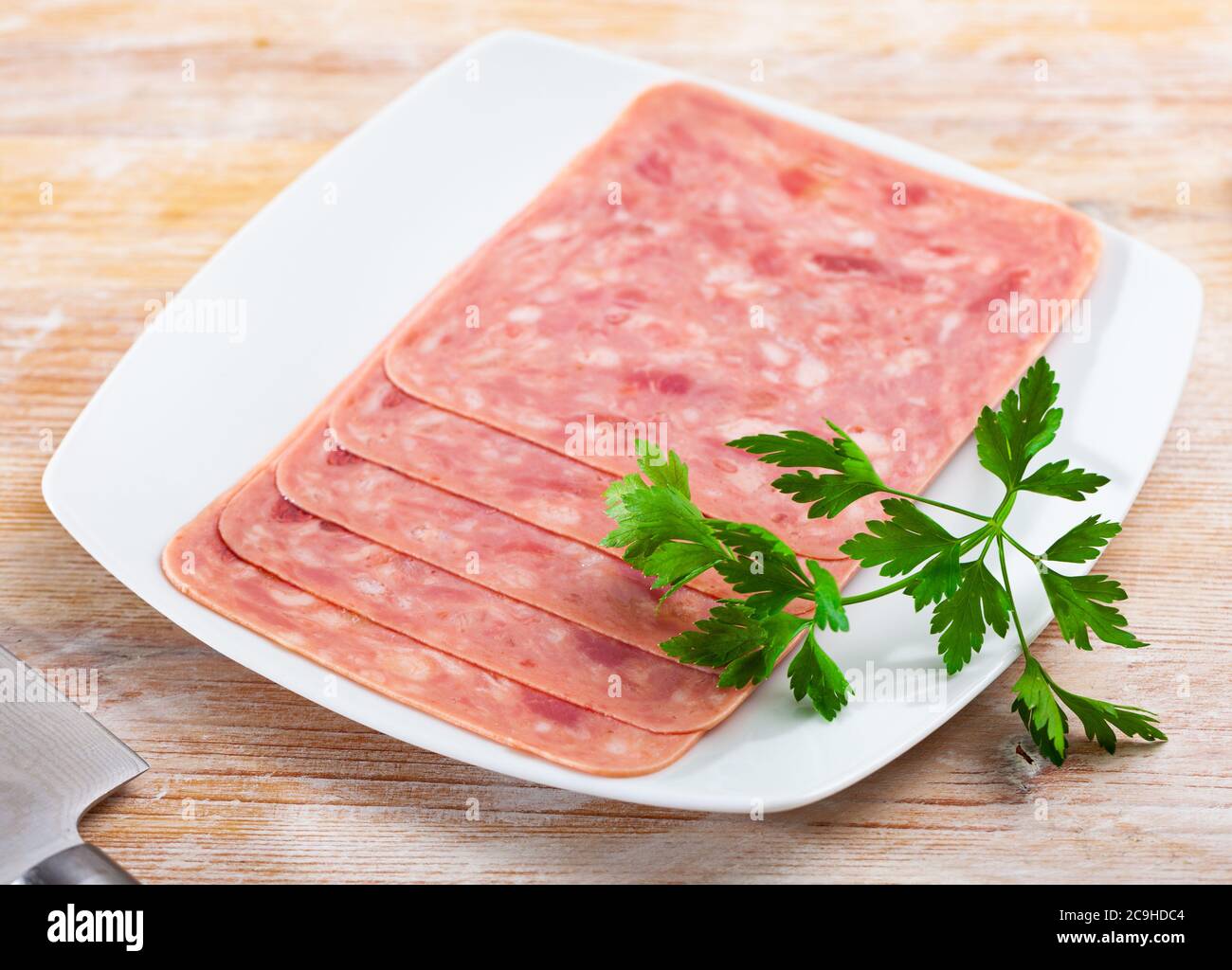 Closeup of sliced tasty ham on white plate Stock Photo - Alamy