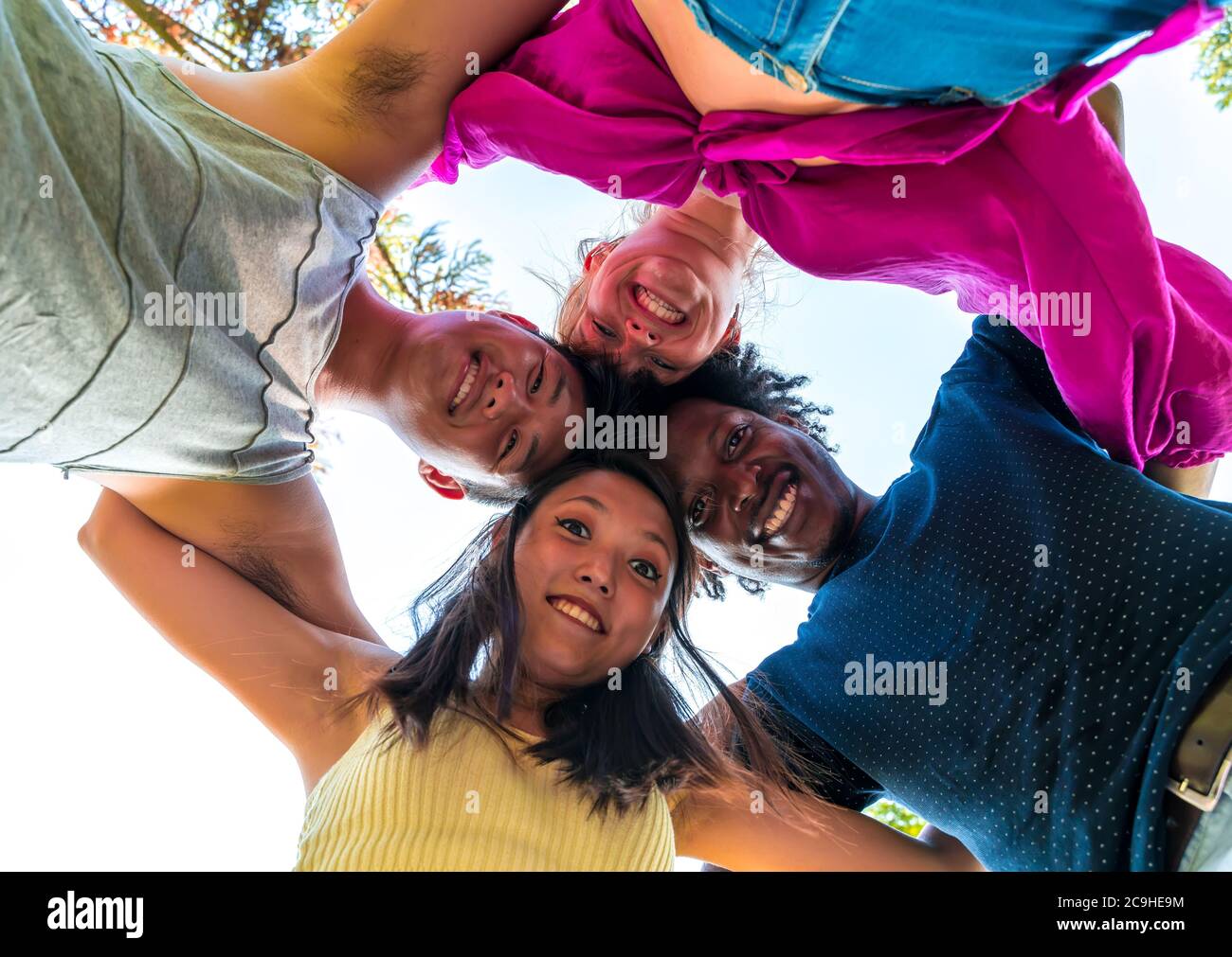 A group of friends or a team sticking their heads together Stock Photo ...