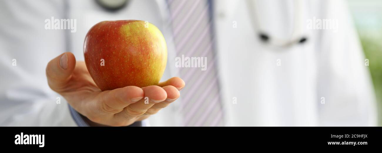 Male medicine therapeutist doctor hands holding red fresh ripe apple ...