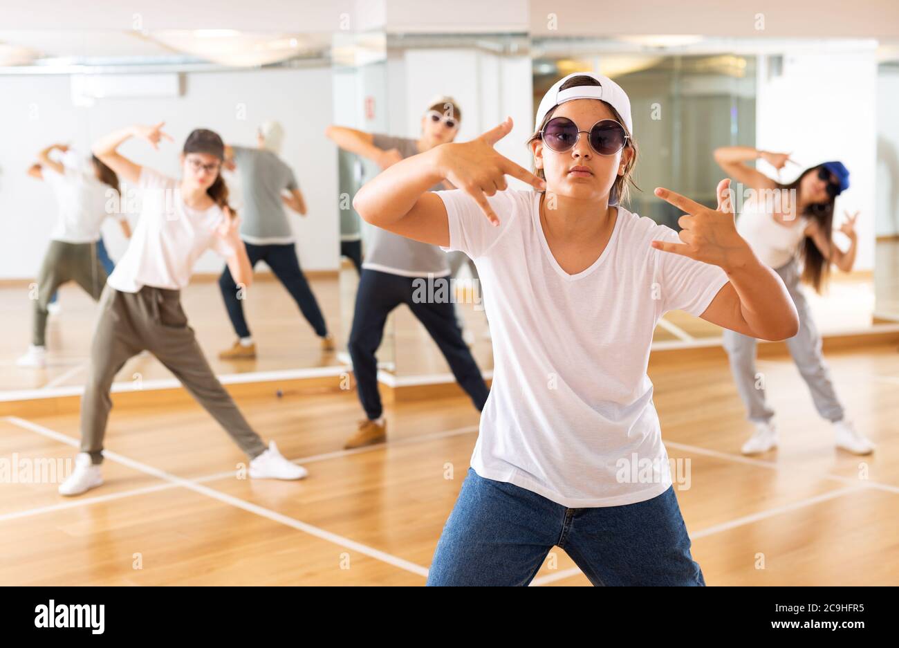 Portrait of emotional teenager girl doing hip hop movements during ...