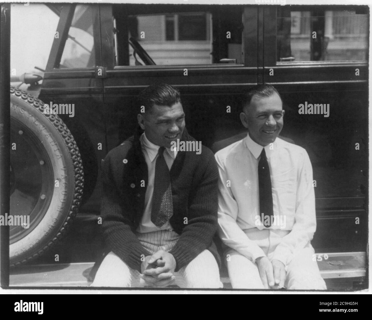 Jack Dempsey at his training camp, June 1921- seated with man on auto ...
