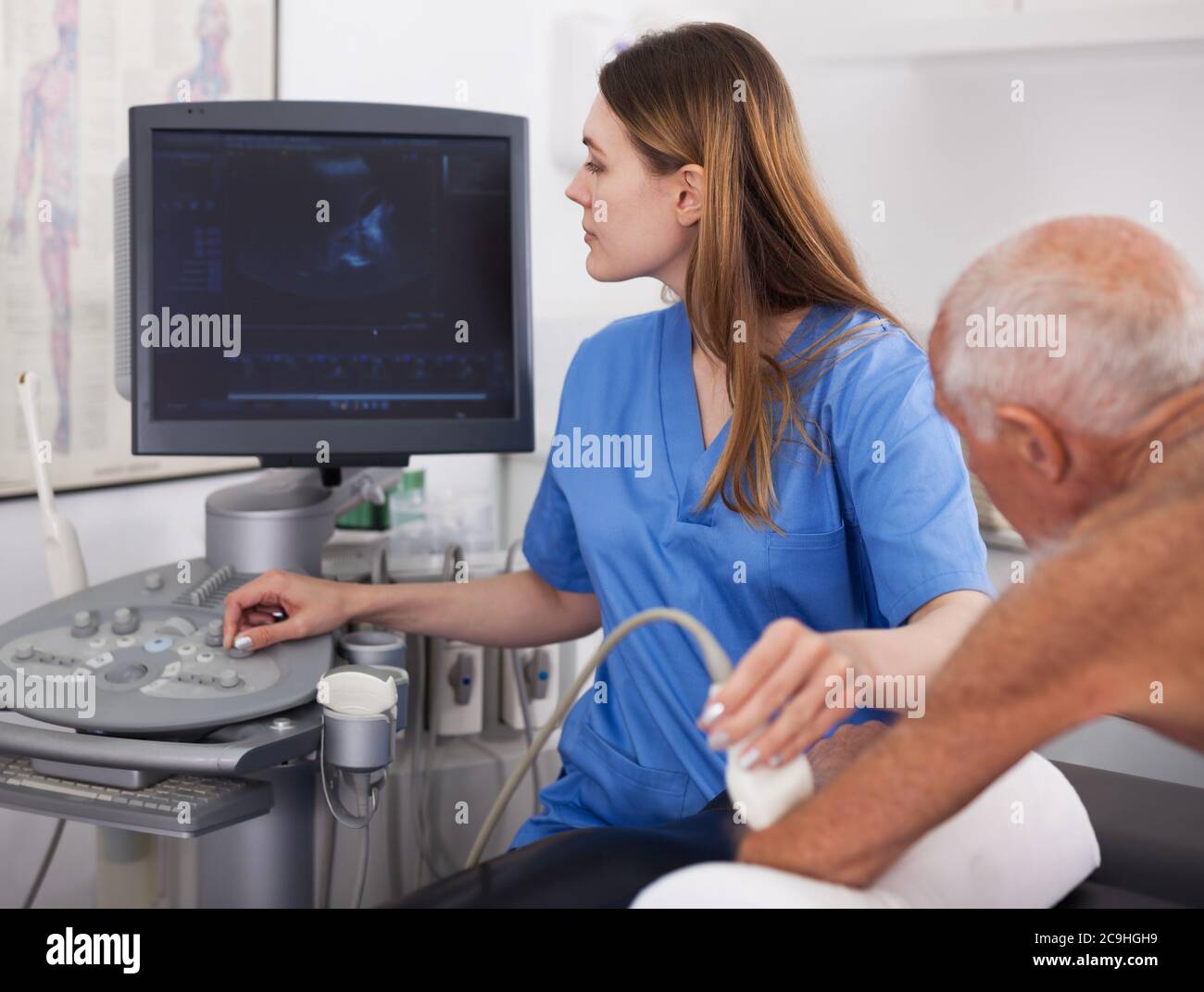 Female doctor using ultrasound scan examining male patient at modern ...