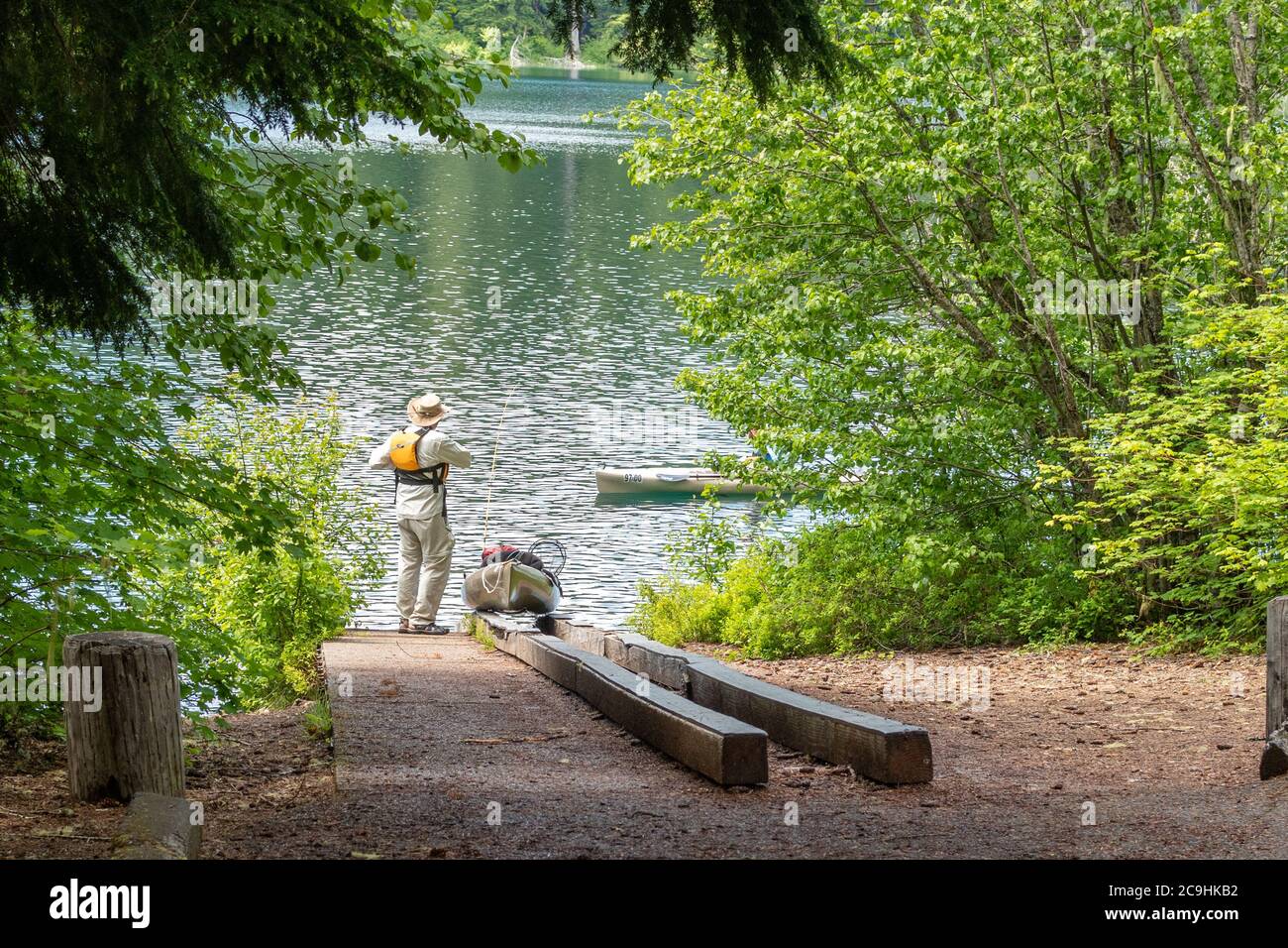 Older man getting ready to go fishing from his kayak with his female ...