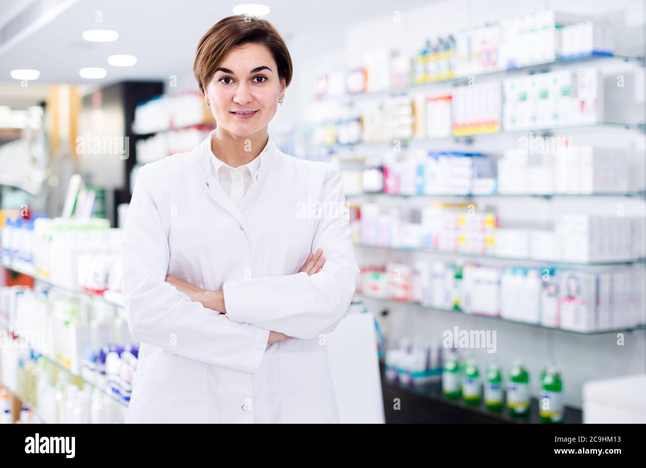 positive european female pharmacist demonstrating assortment of ...