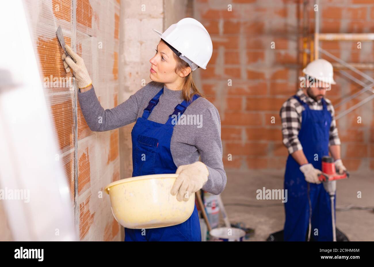 Portrait of two builders in process of finishing work in cottage Stock ...