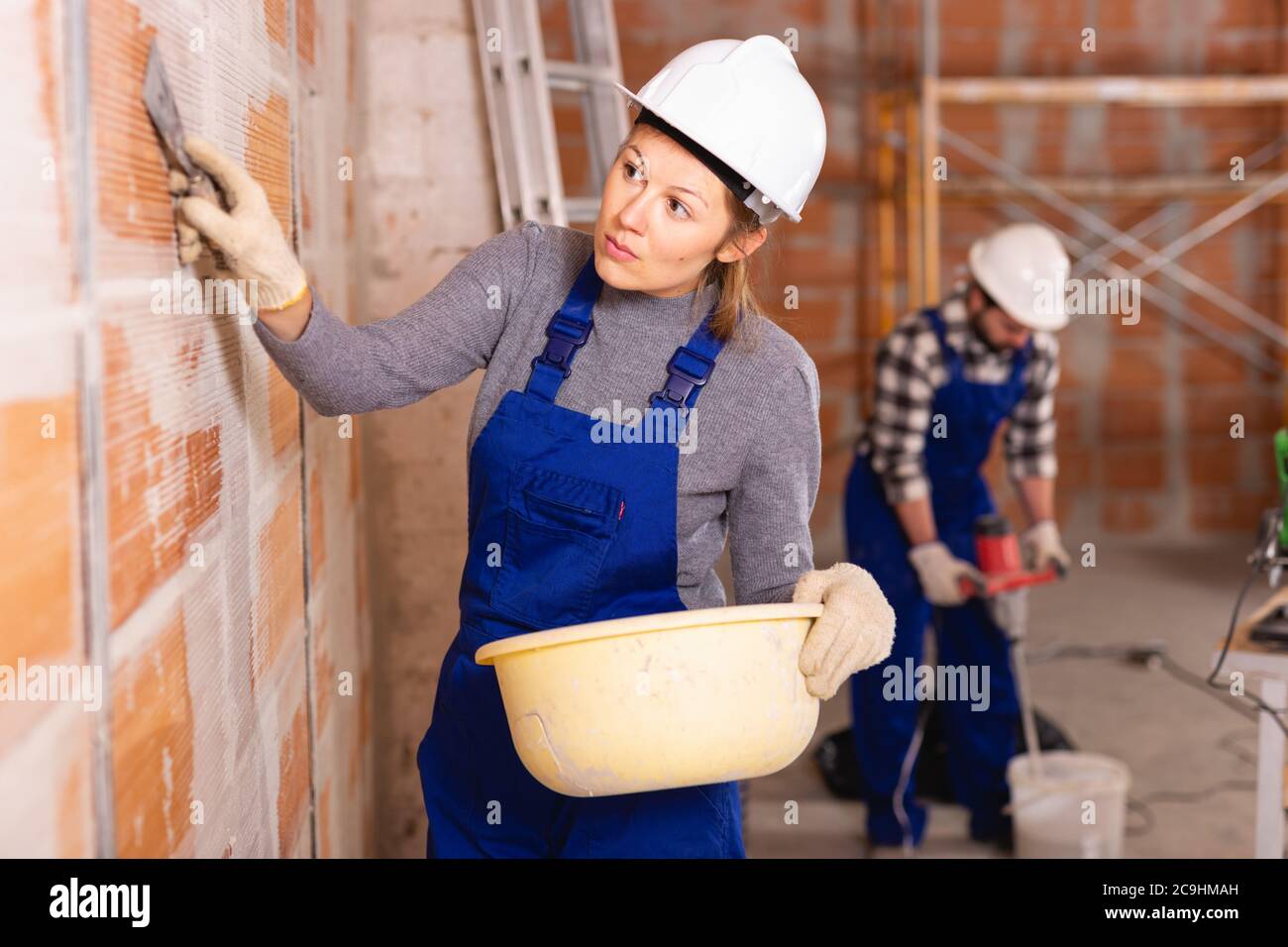Portrait of two builders in process of finishing work in cottage Stock ...
