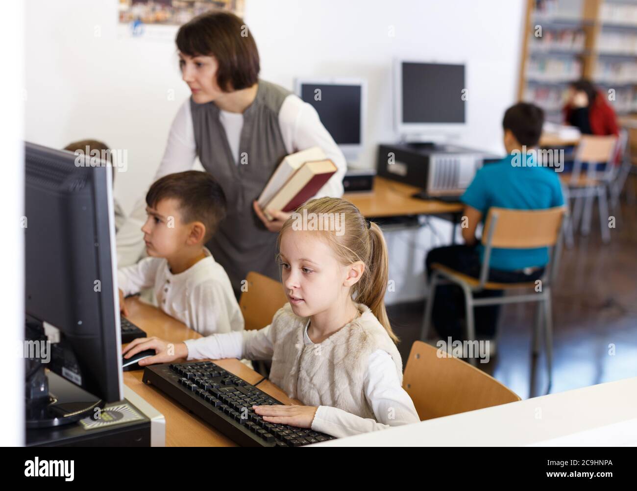Portrait of serious tween girl during lesson in computer room of school ...