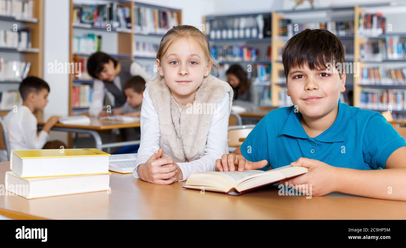 School friends spending time together in library, reading books Stock ...