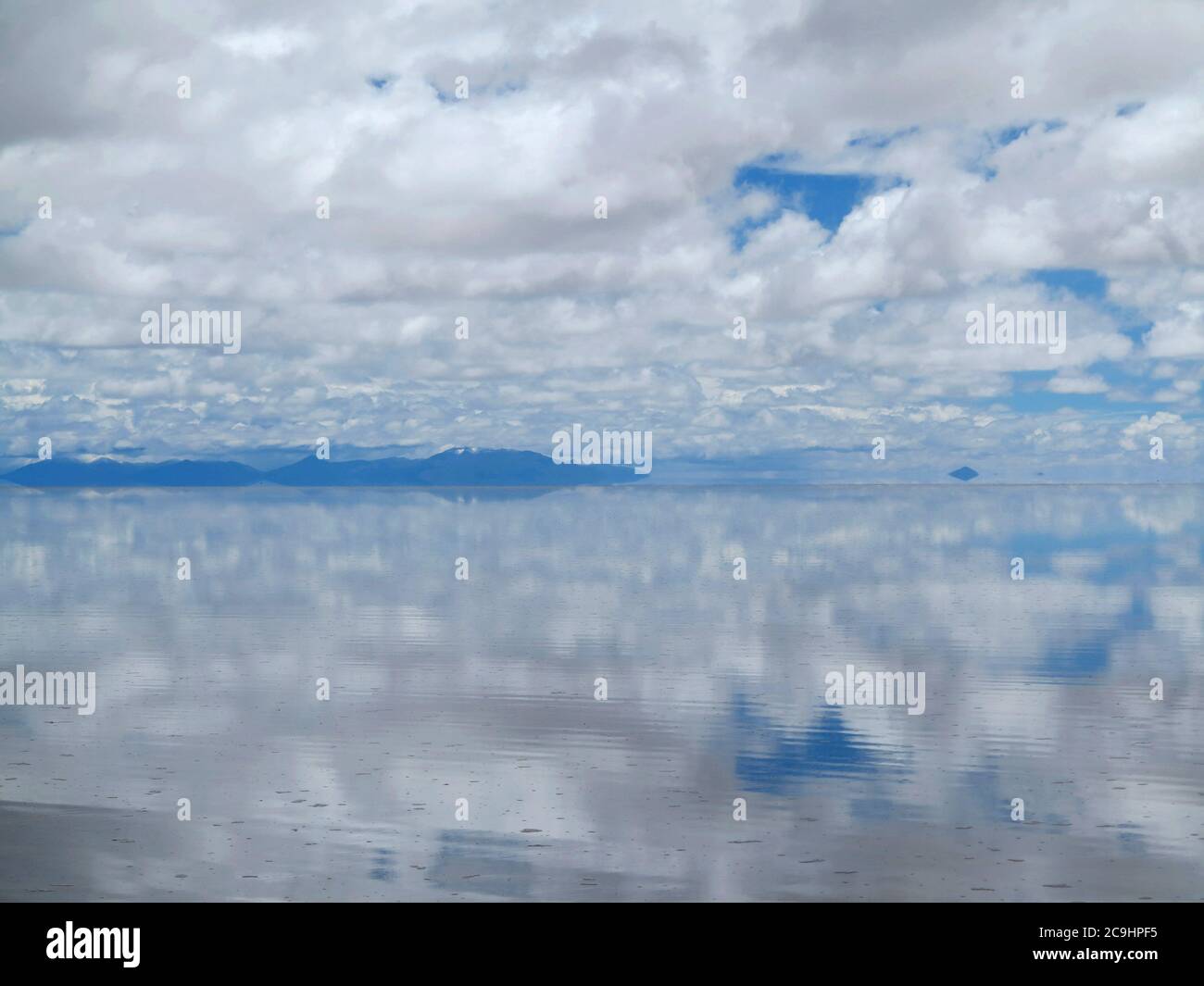 panorama of the perfect white flat salt desert with blue cloudy sky ...