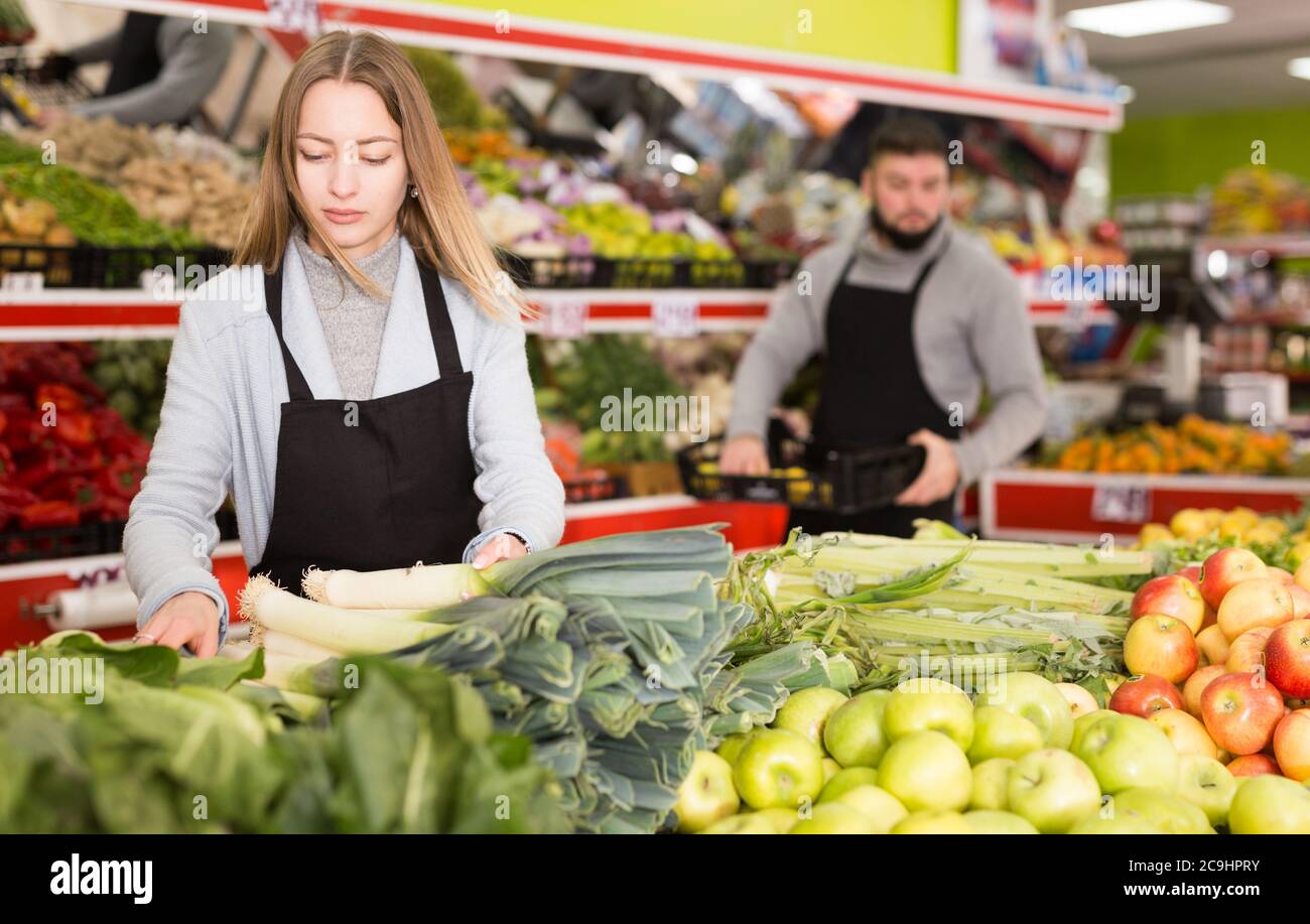 Shopping assistant puts leek on supermarket counter Stock Photo - Alamy