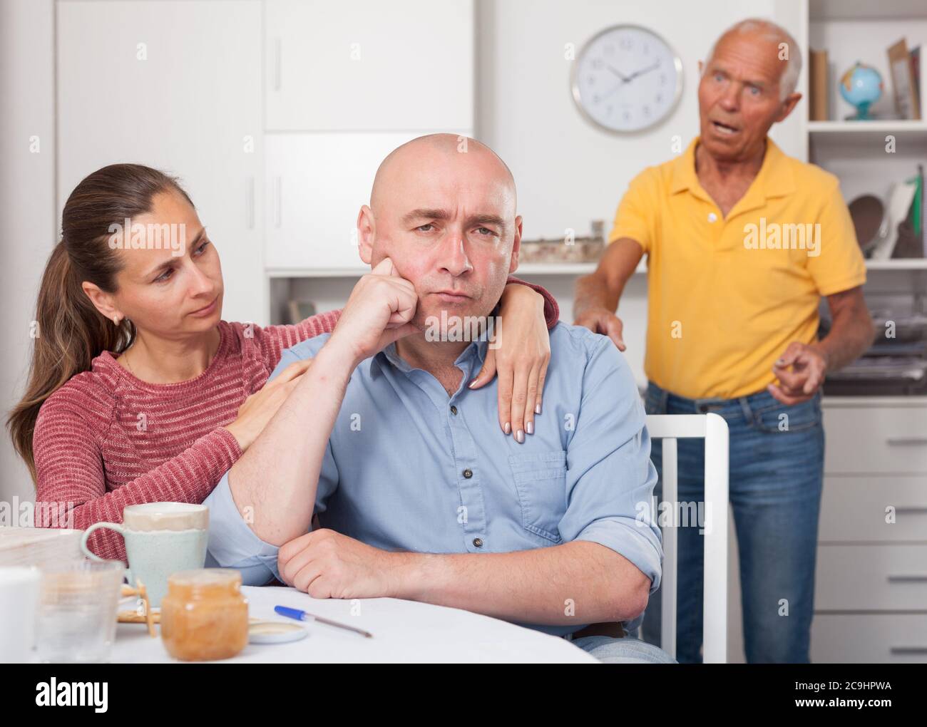 Wife calms husband after his quarrel with father Stock Photo - Alamy
