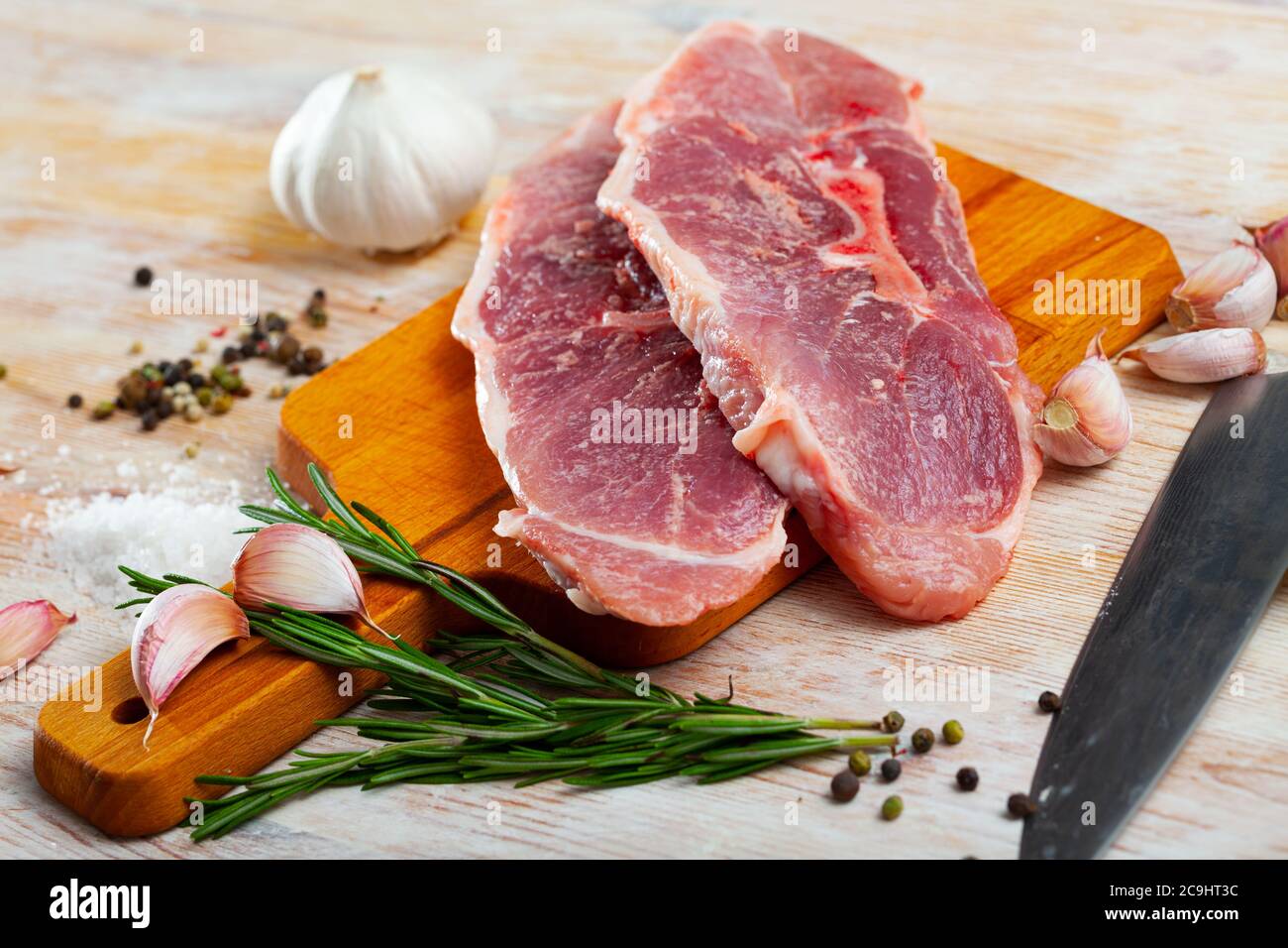 Close up of raw pork's fillet shoulder with garlic and rosemary on ...