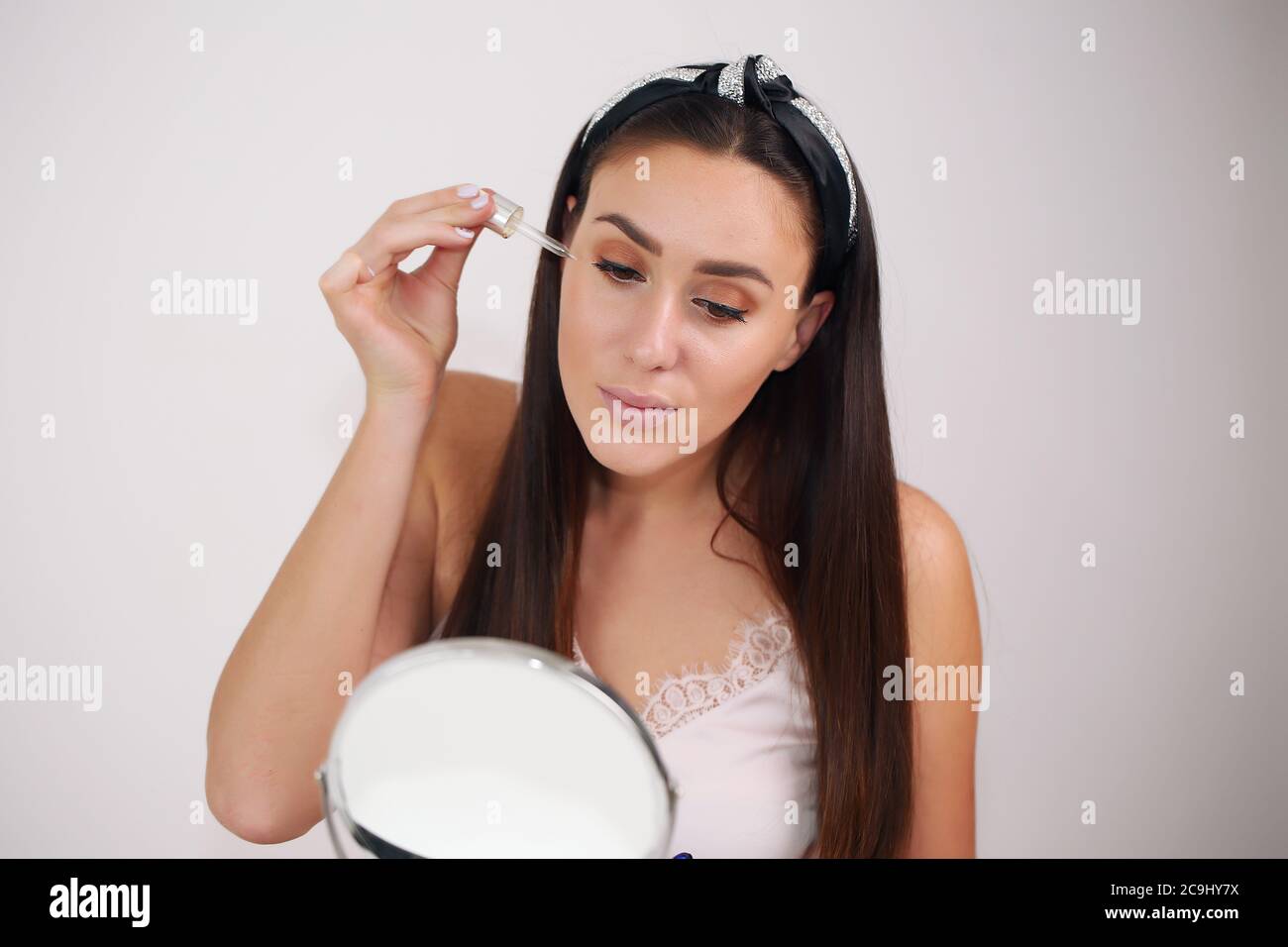 Happy pretty woman getting ready to apply serum at the beginning of the ...
