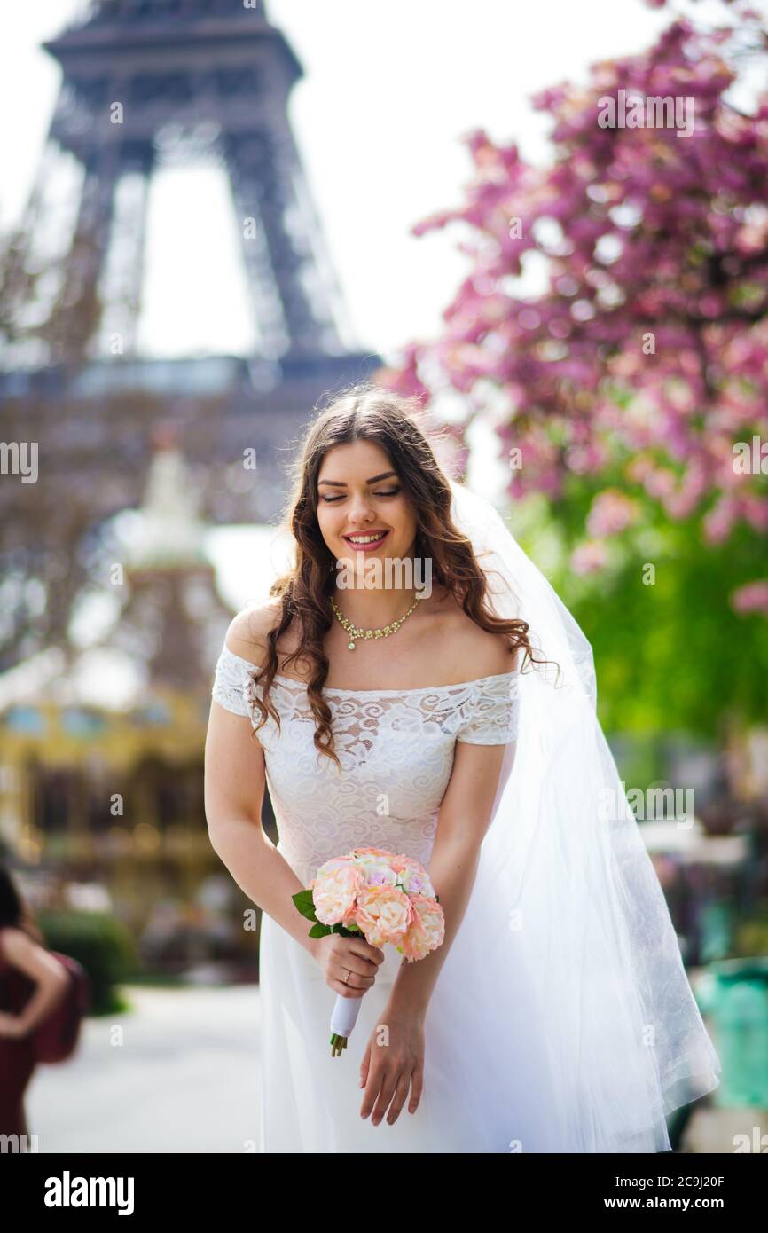 Beautiful bride in rich wedding dress whirls on the square before the ...