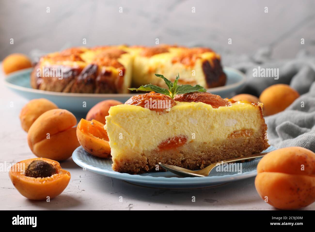Homemade cheesecake with apricots on light gray background, horizontal ...