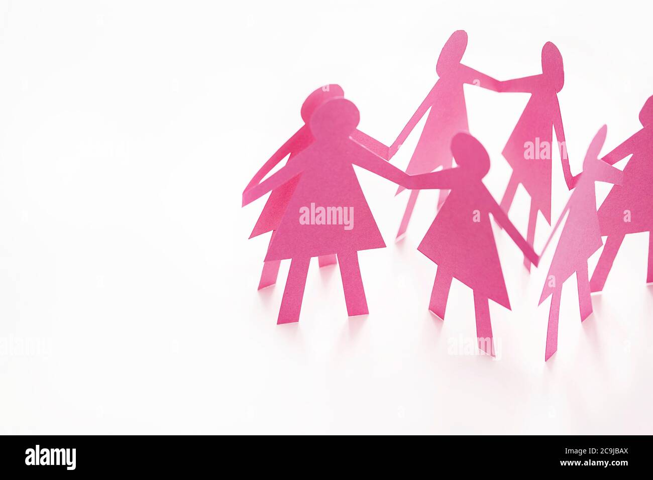 Pink cut out paper chain female figures against a white background ...