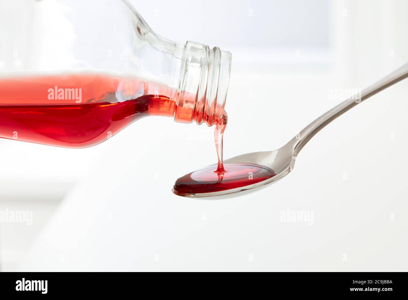 Cough syrup pouring onto a spoon Stock Photo - Alamy