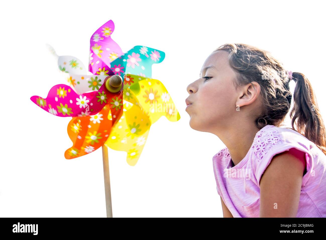 Girl blowing multi coloured paper windmill, close-up Stock Photo - Alamy