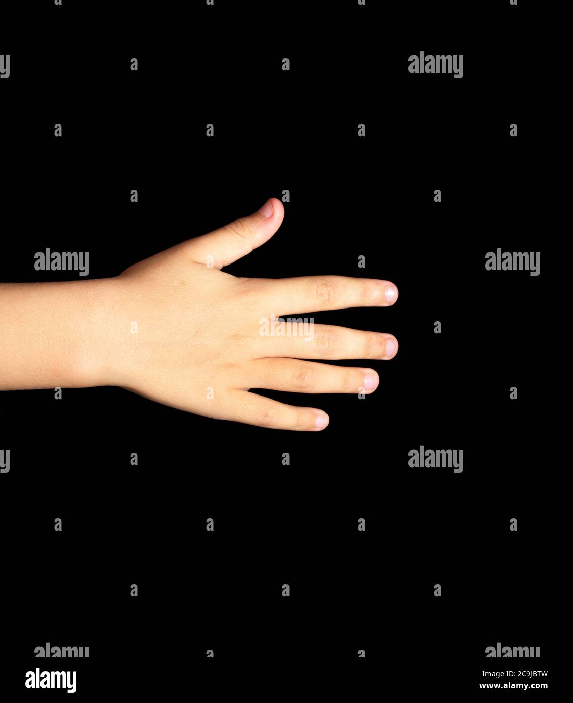 Child's hand against a plain black background Stock Photo - Alamy