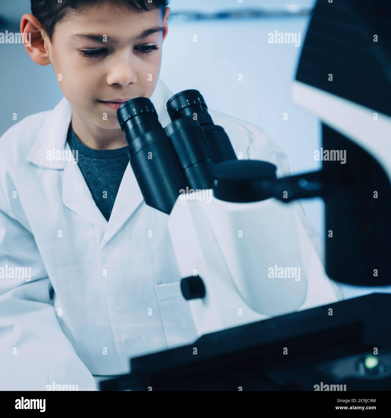 Schoolboy using light microscope Stock Photo - Alamy