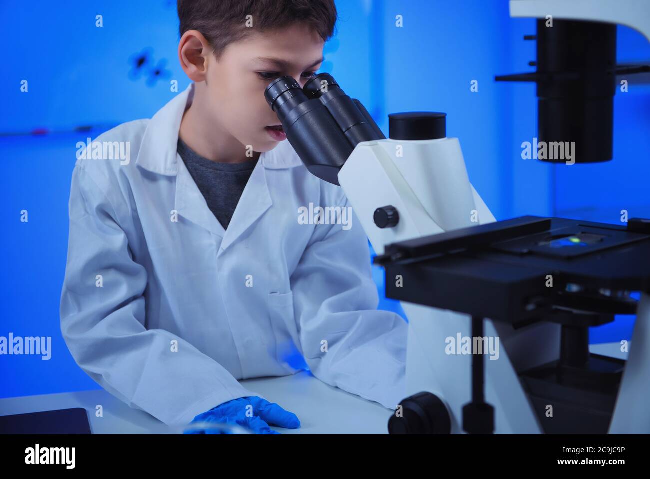 Schoolboy using light microscope Stock Photo - Alamy