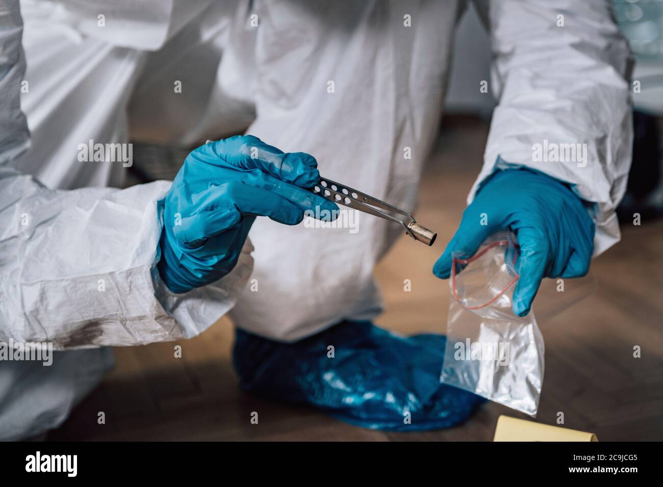 Crime scene. Forensics expert collecting evidence from a crime scene ...