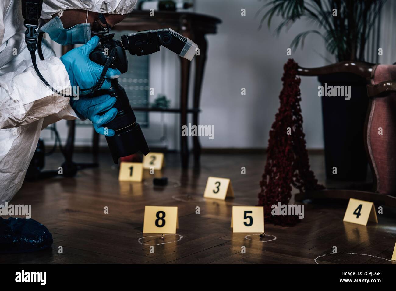 Crime scene. Forensics expert photographing evidence at a crime scene ...