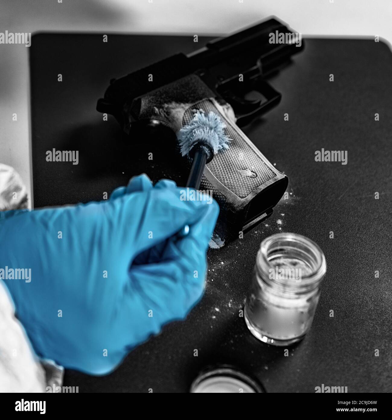 Forensic technician examining weapon, looking for fingerprints ...