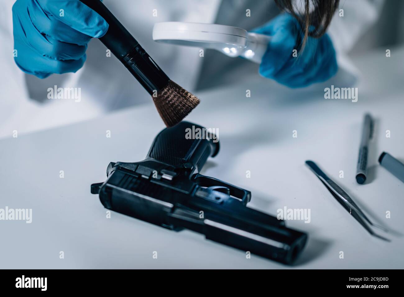 Forensic Science in Lab. Forensic Scientist examining gun for evidence ...