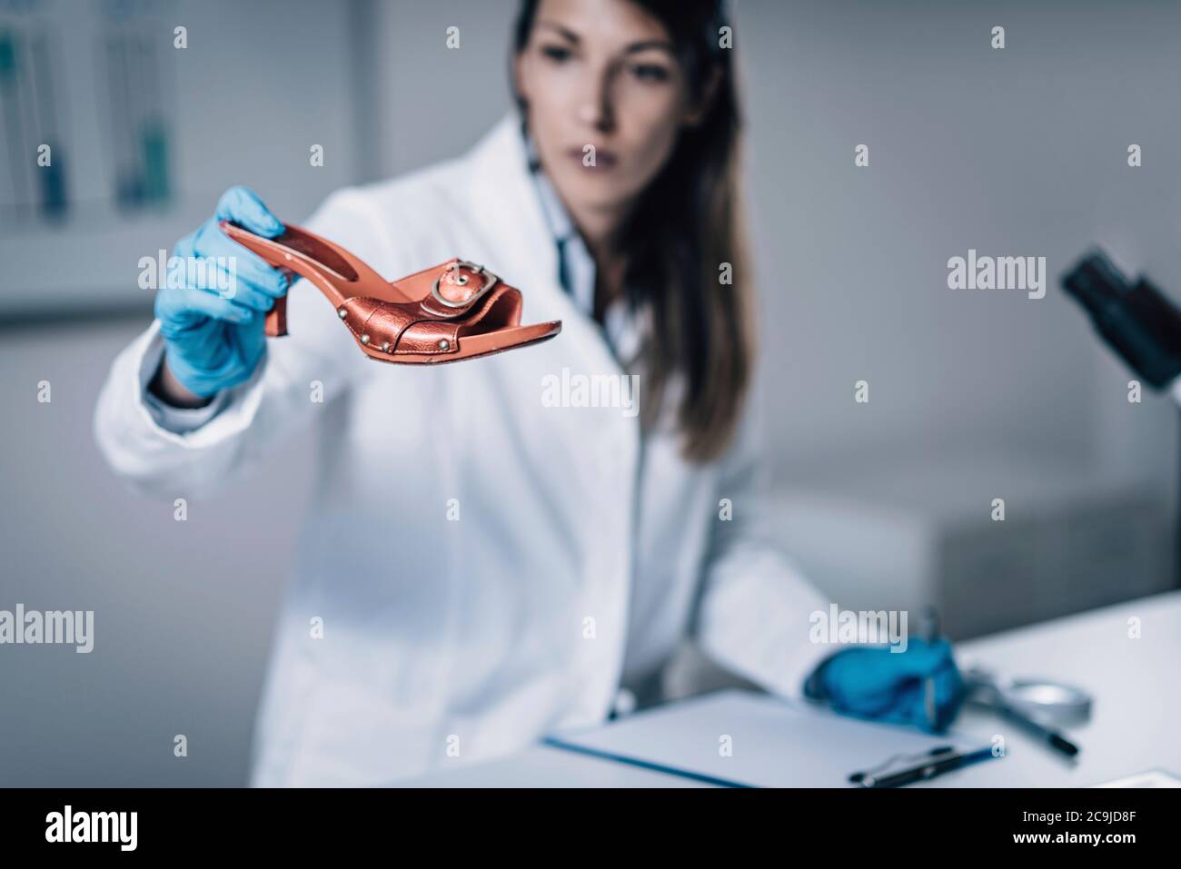 Forensic Science in Lab. Forensic Scientist examining shoe for evidence ...