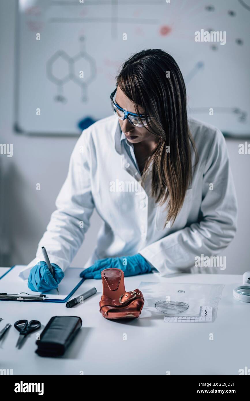Forensic Science in Lab. Forensic Scientist examining shoe for evidence ...