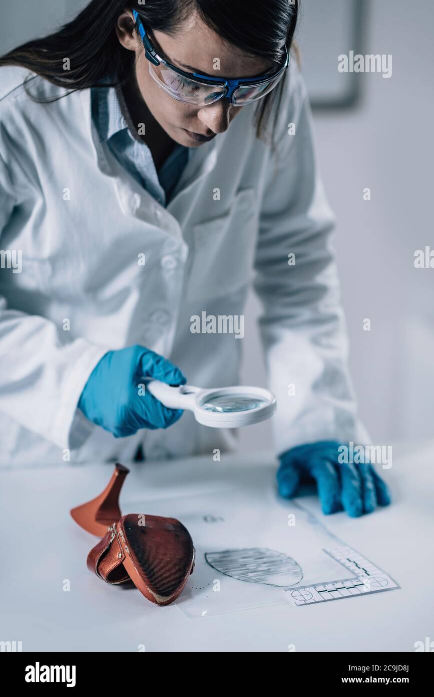 Forensic Science in Lab. Forensic Scientist examining shoe for evidence ...