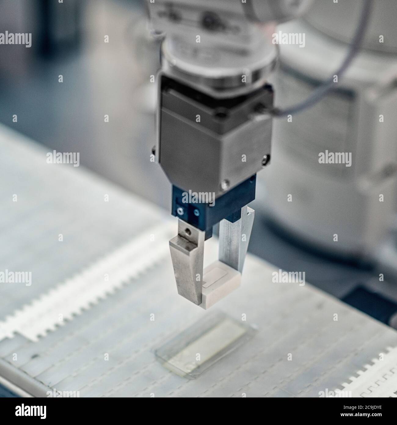 Articulated robotic arm working on a conveyor belt in a high tech ...