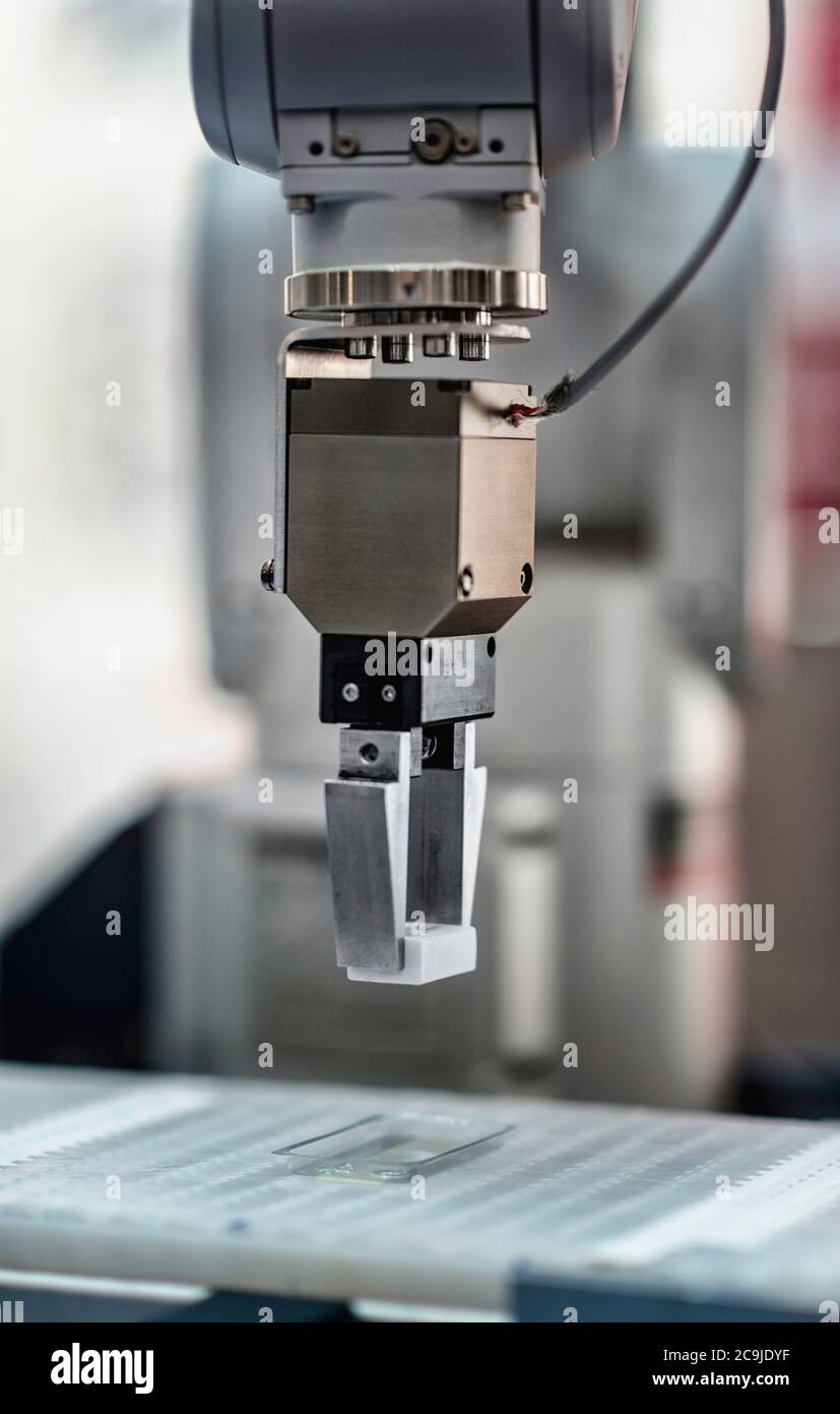 Articulated robotic arm working on a conveyor belt in a high tech ...