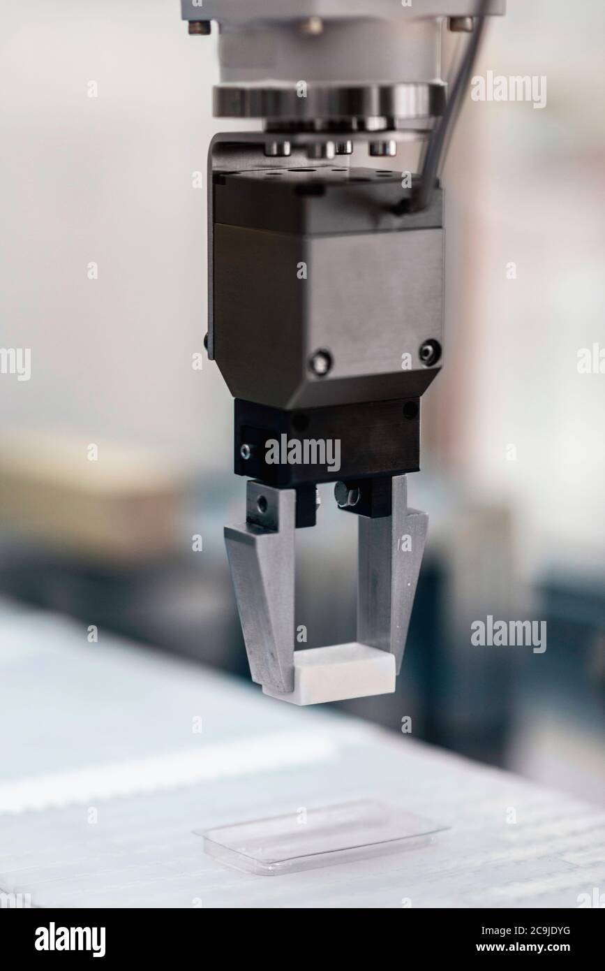 Articulated robotic arm working on a conveyor belt in a high tech ...