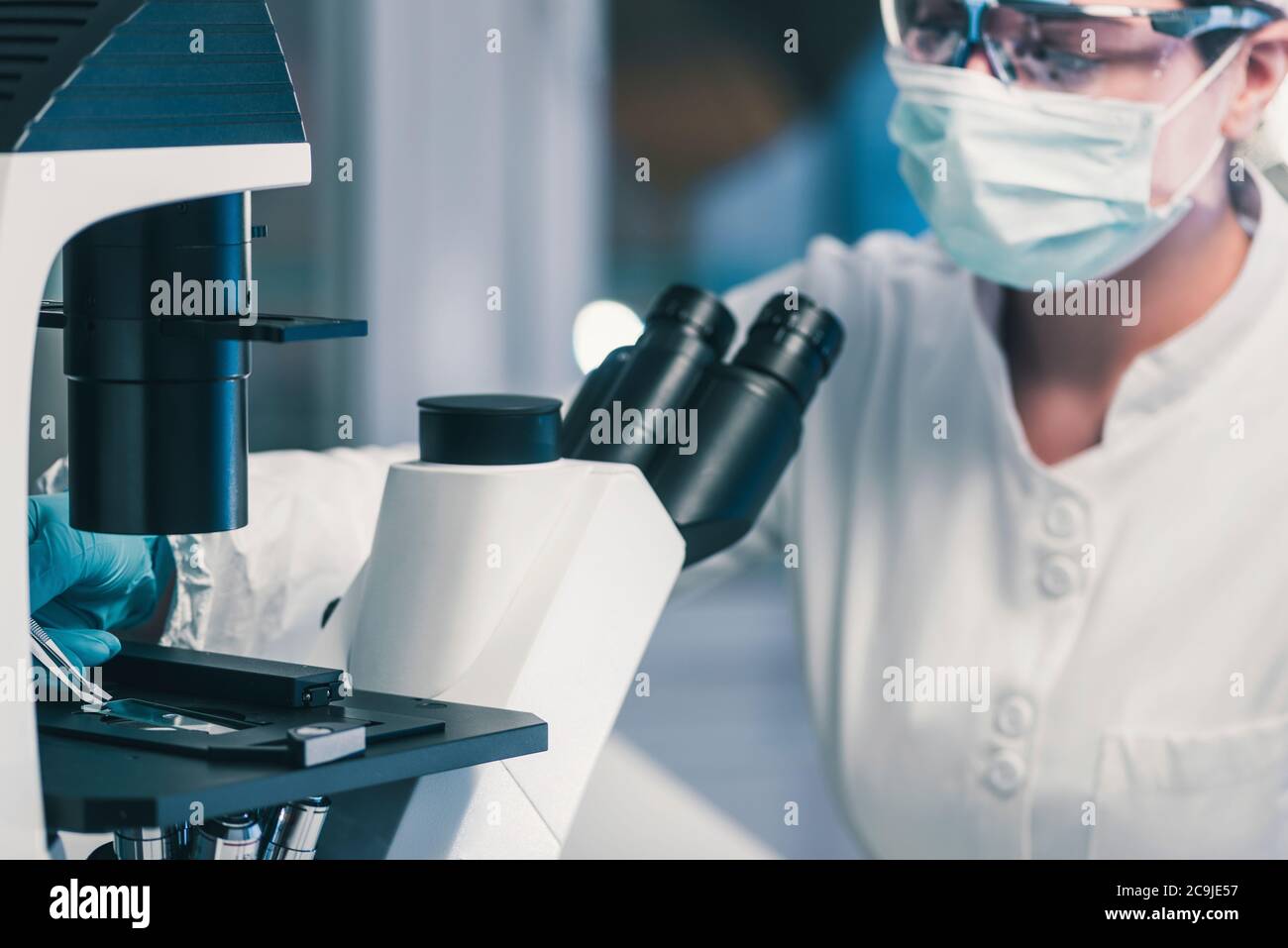 Microbiologist using light microscope Stock Photo - Alamy