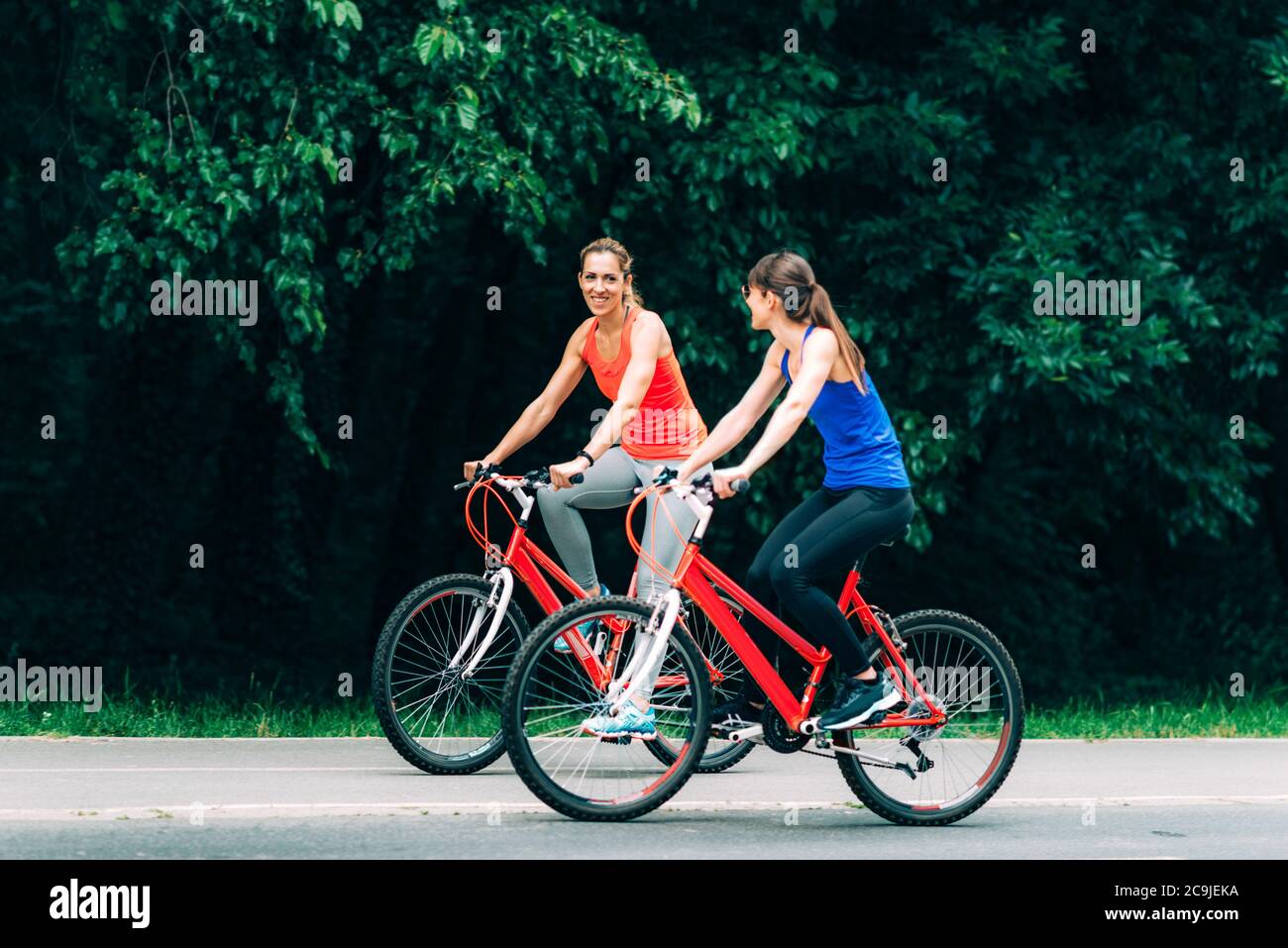 Friends cycling in park hi-res stock photography and images - Alamy