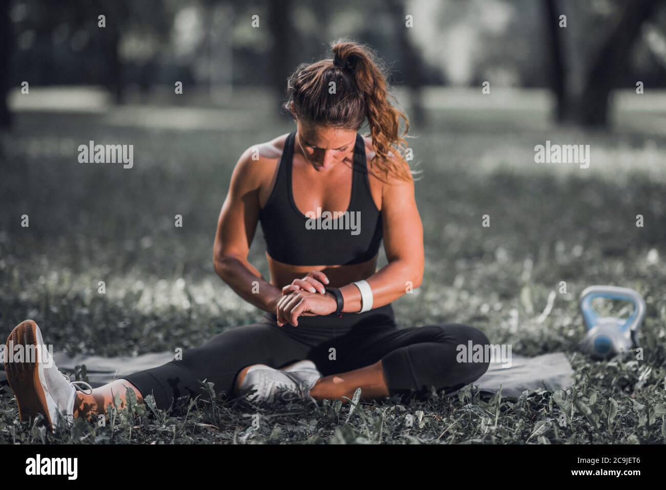 Woman checking progress on smartwatch after training outdoors Stock ...
