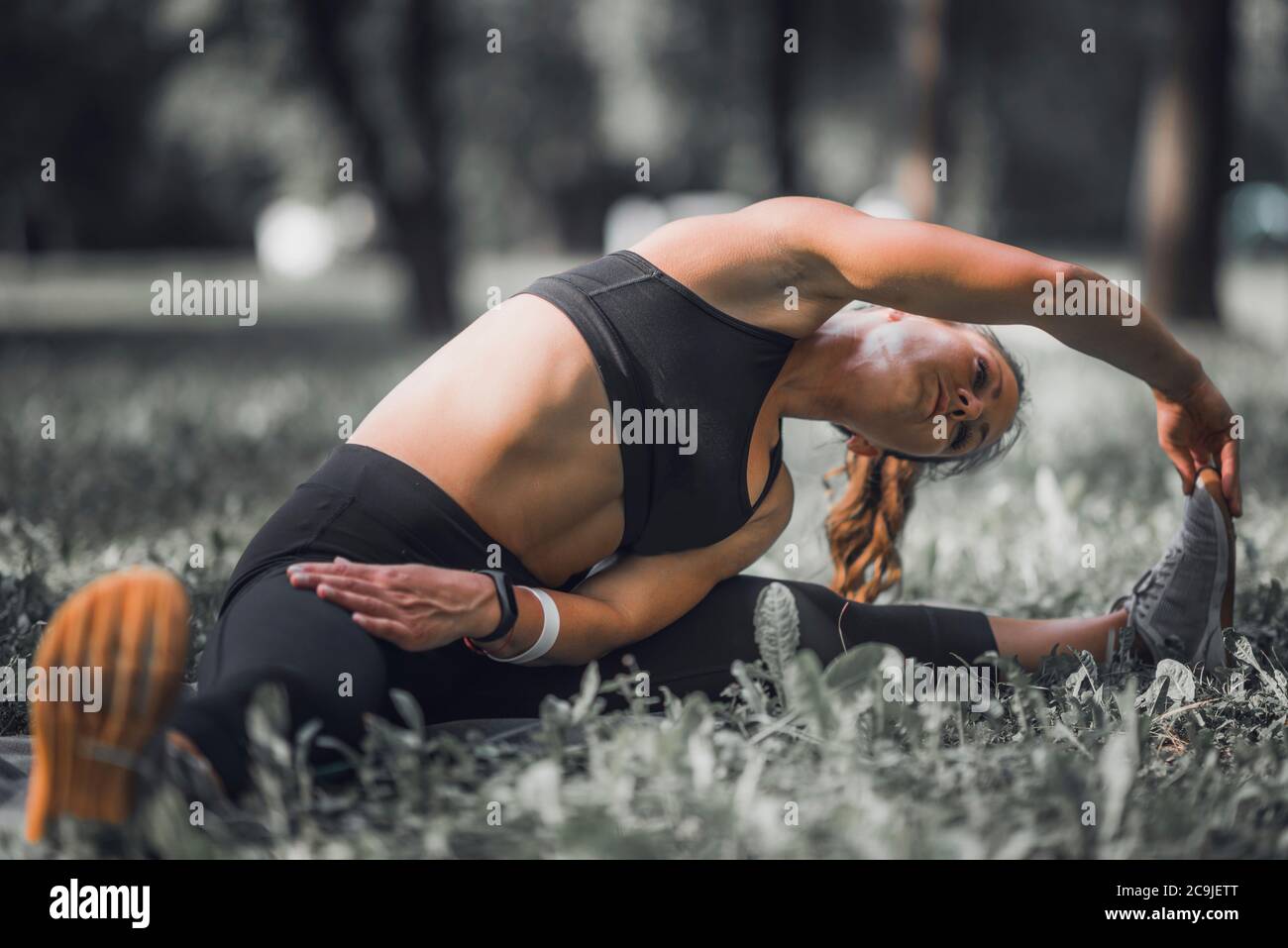 Stretching. Female athlete stretching after exercise Stock Photo - Alamy