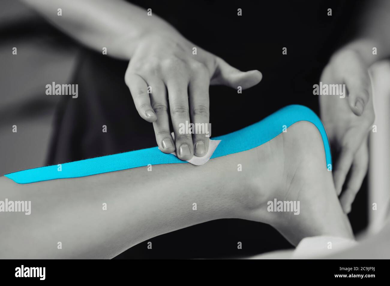 Physical therapist placing kinesio tape on patient's Achilles tendon Stock Photo - Alamy