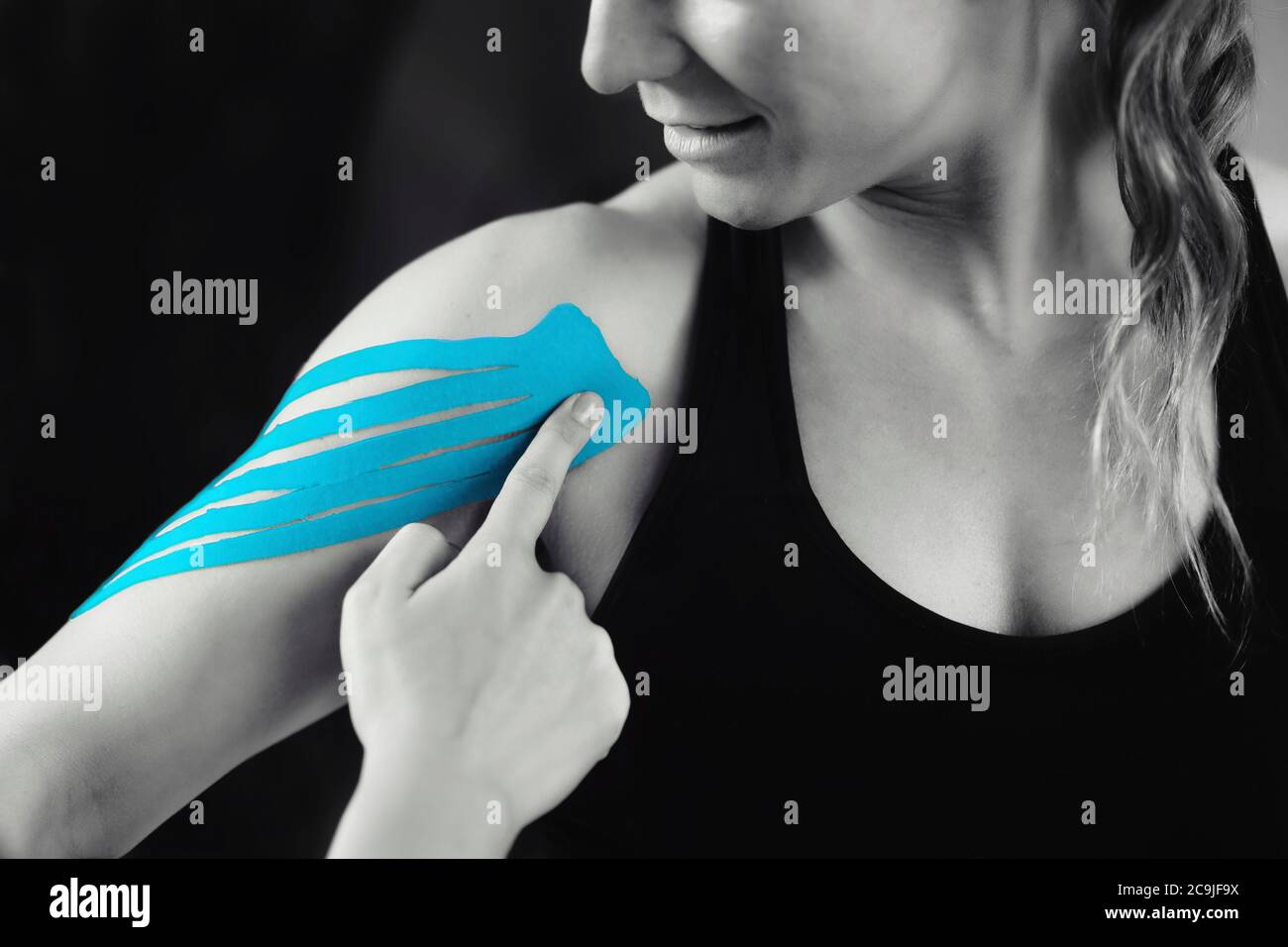 Physical therapist placing kinesio tape on patient's shoulder Stock Photo - Alamy