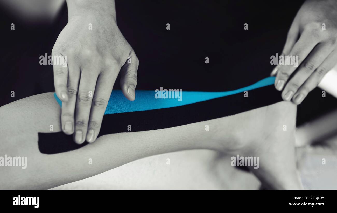 Physical therapist placing kinesio tape on patient's Achilles tendon ...