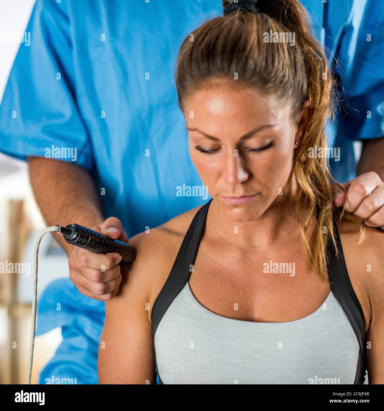 Laser therapy. Physical therapist treating patient's shoulder Stock ...