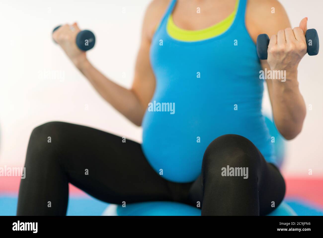 Prenatal exercising. Pregnant woman doing simple exercise with ...