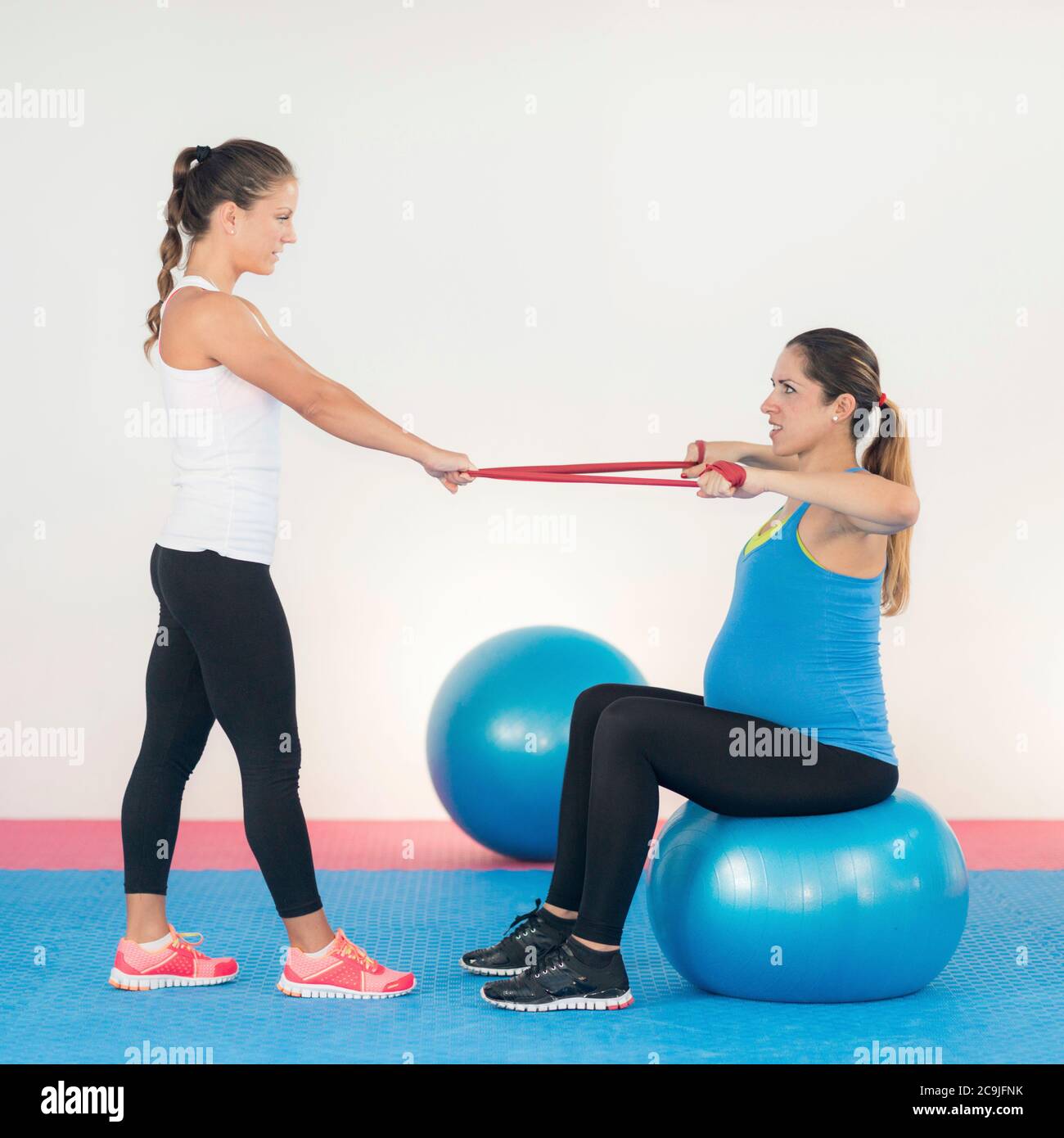 Third trimester pregnant woman doing simple resistance band exercises ...