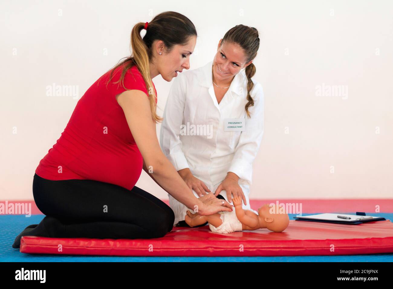 Maternity training. Pregnant woman learning to change a baby's nappy ...