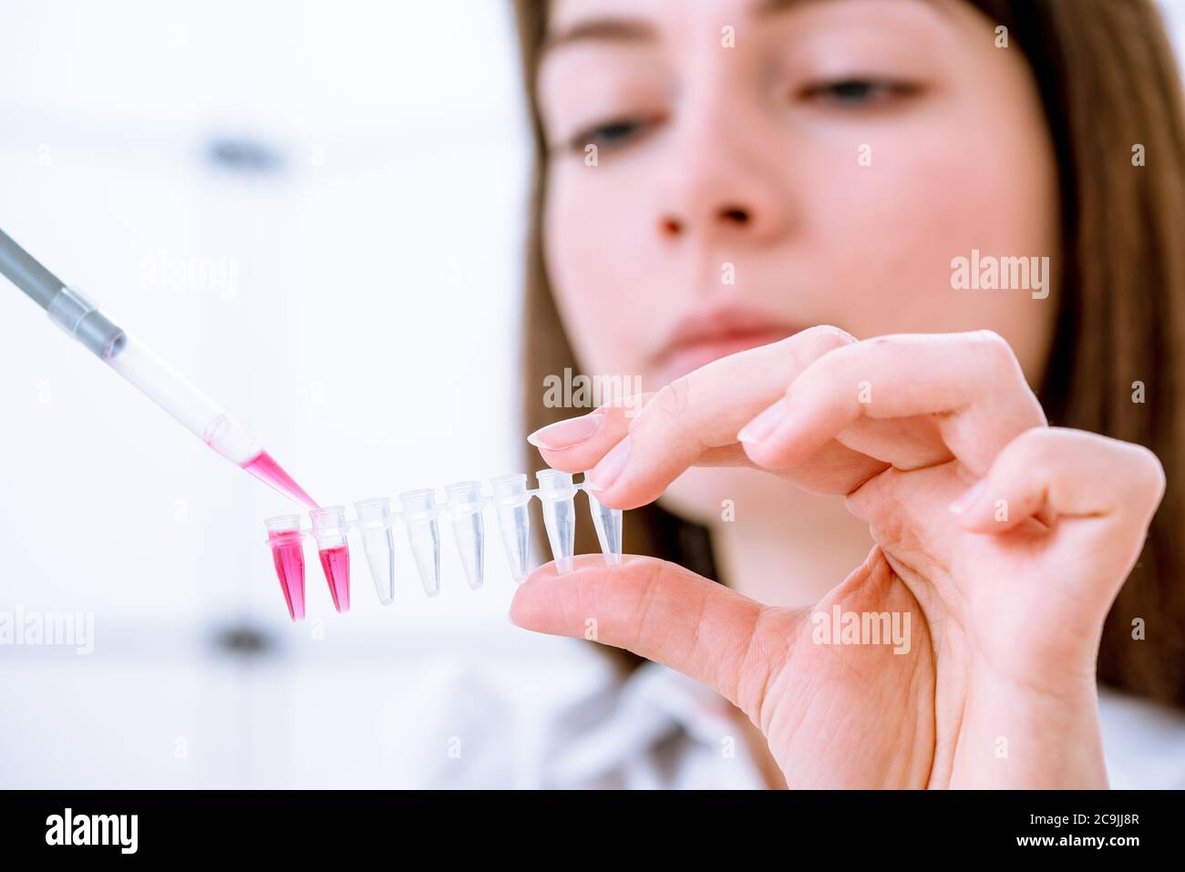 Young woman scientist pipetting sample hi-res stock photography and ...